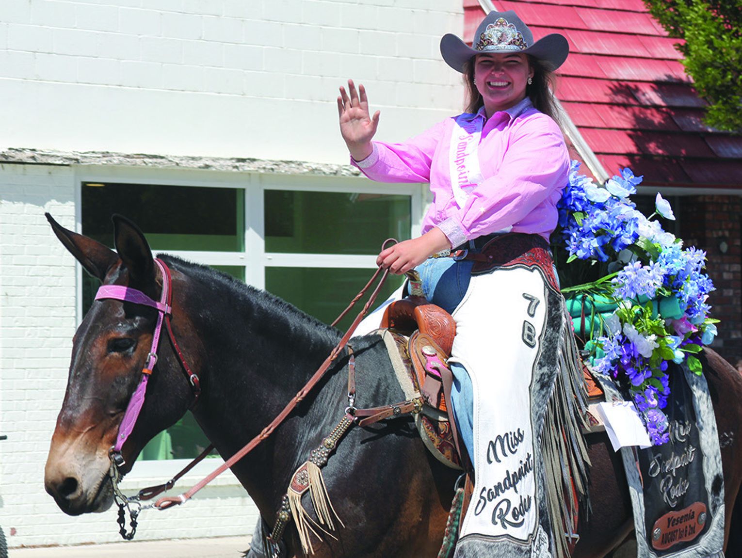 Visiting rodeo royalty wave to the crowd